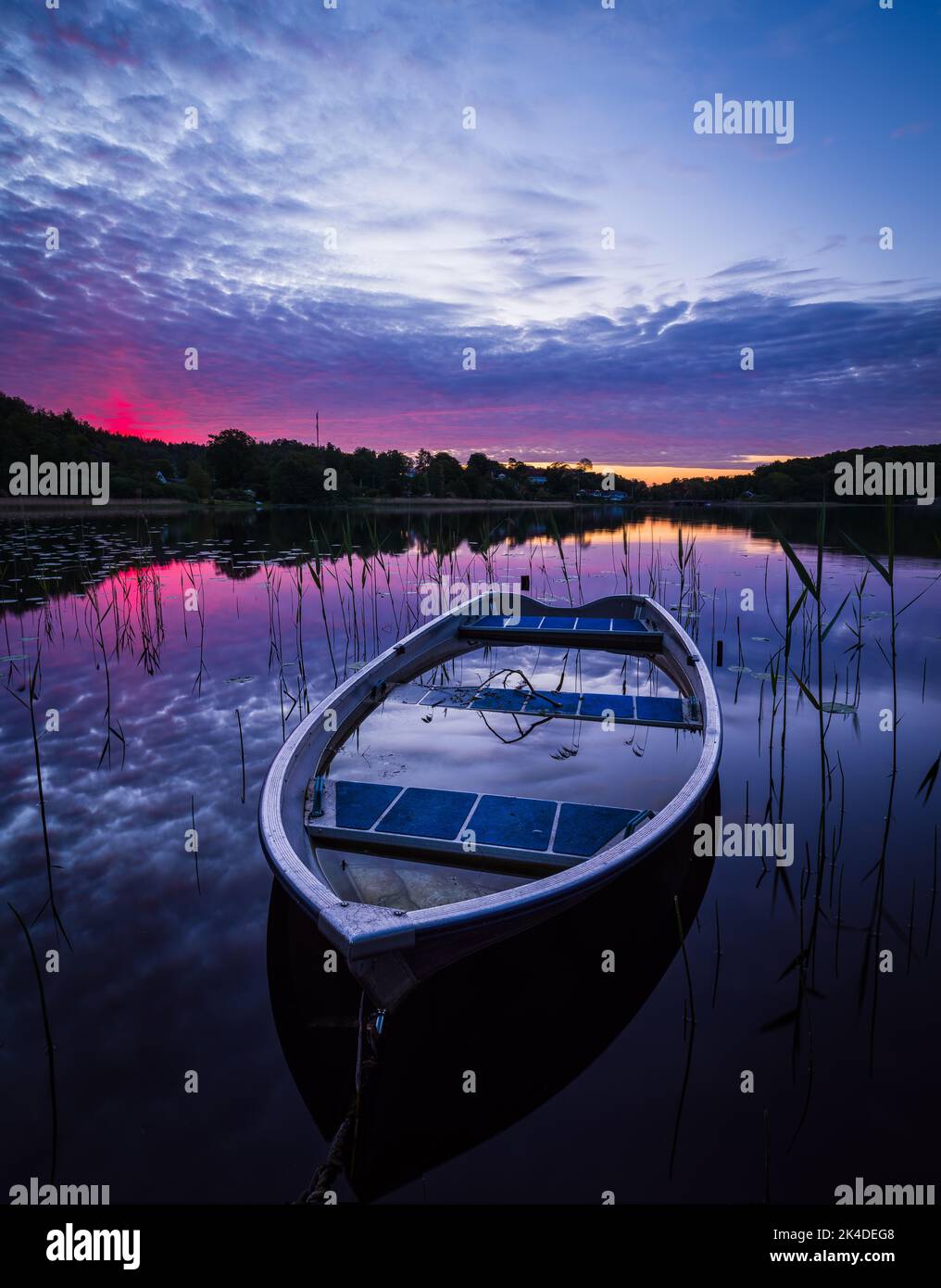 Rowing boat filled with water at sunrise Stock Photo - Alamy