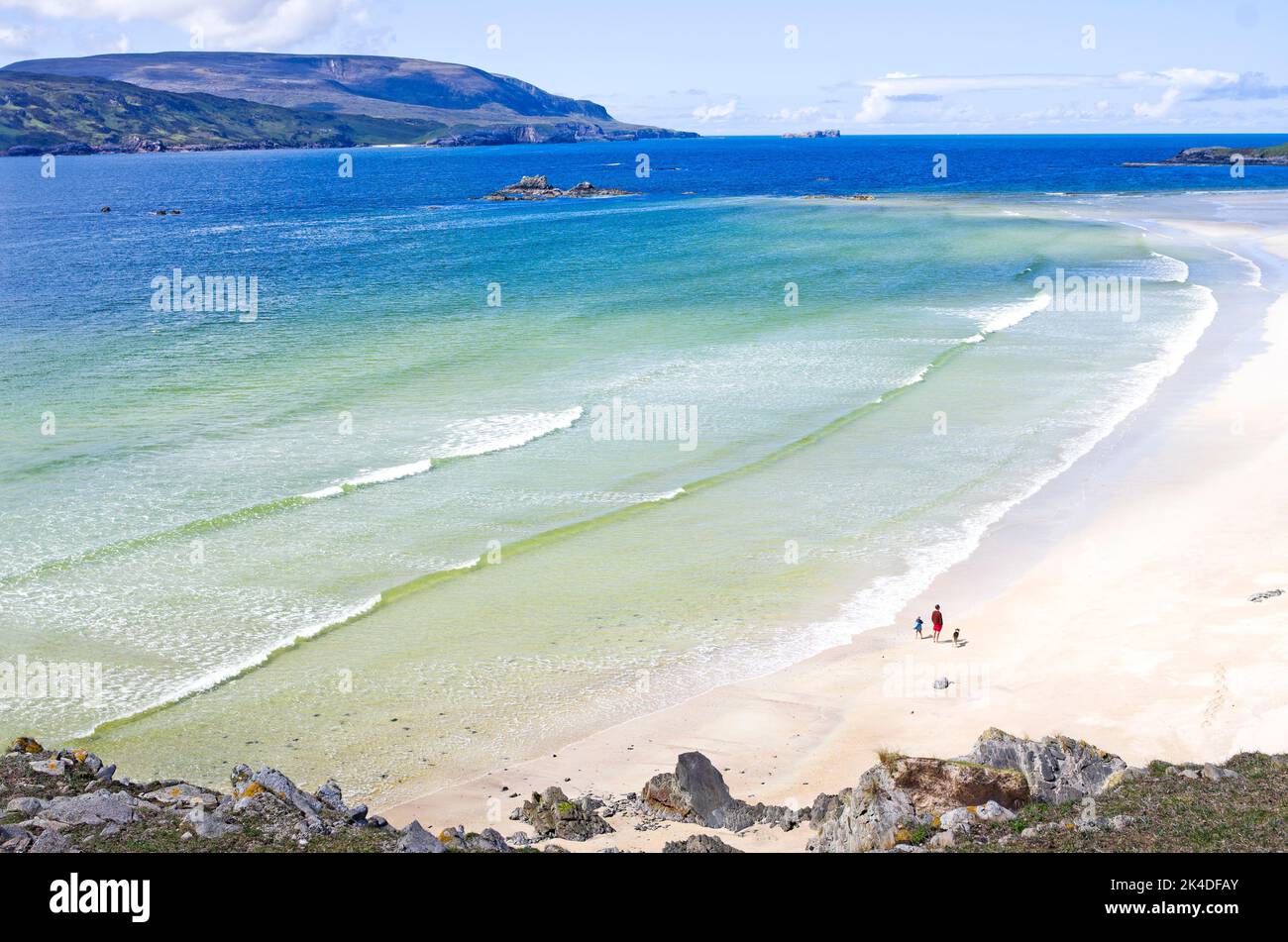 2 people and dog at waters edge on sandy beach hi-res stock photography ...