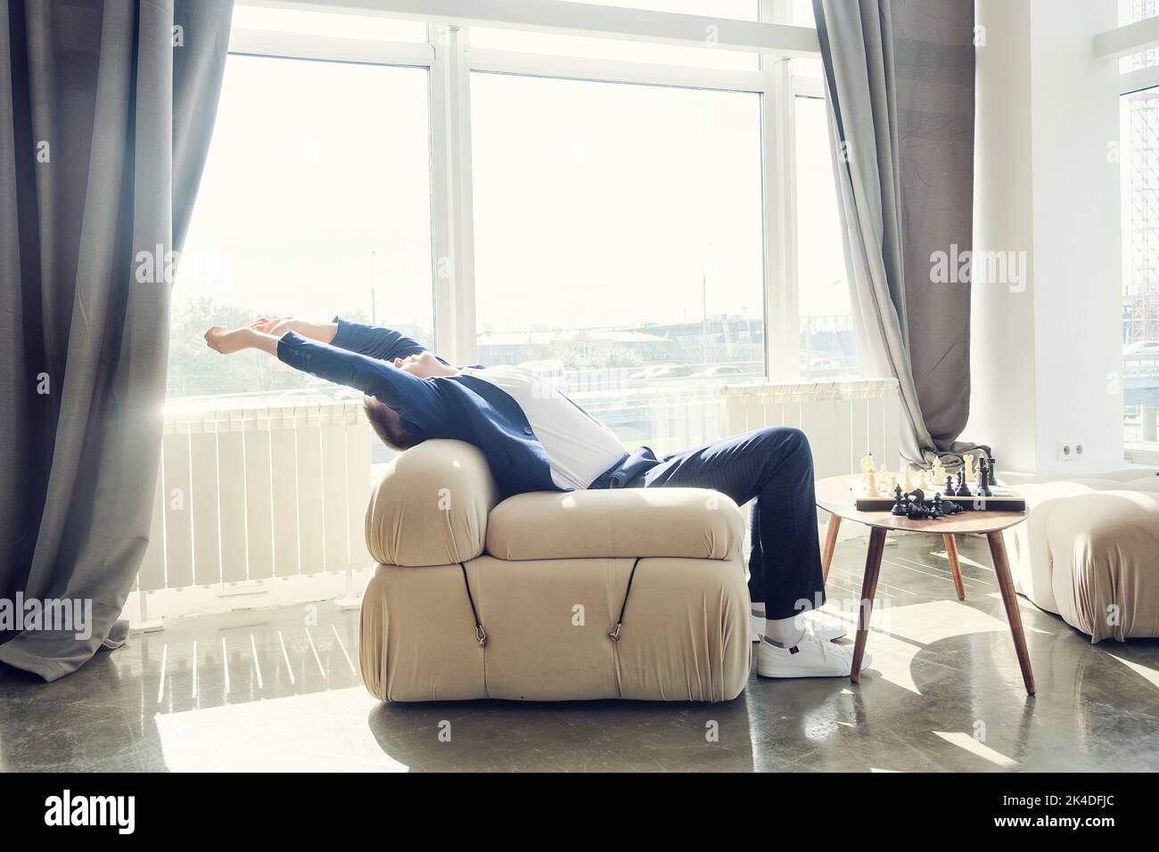 the boy leaned back in his chair resting after playing chess Stock ...