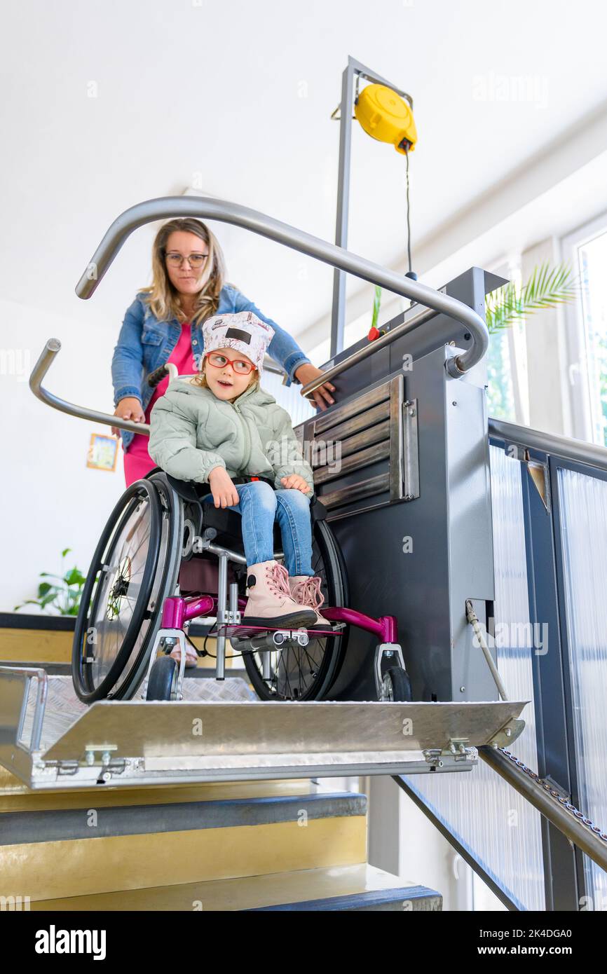 Mother with a young child living with cerebral palsy using electric ...