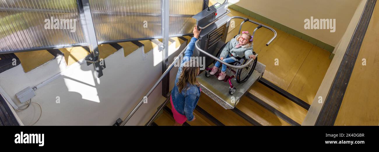 Mother with a young child living with cerebral palsy using electric ...