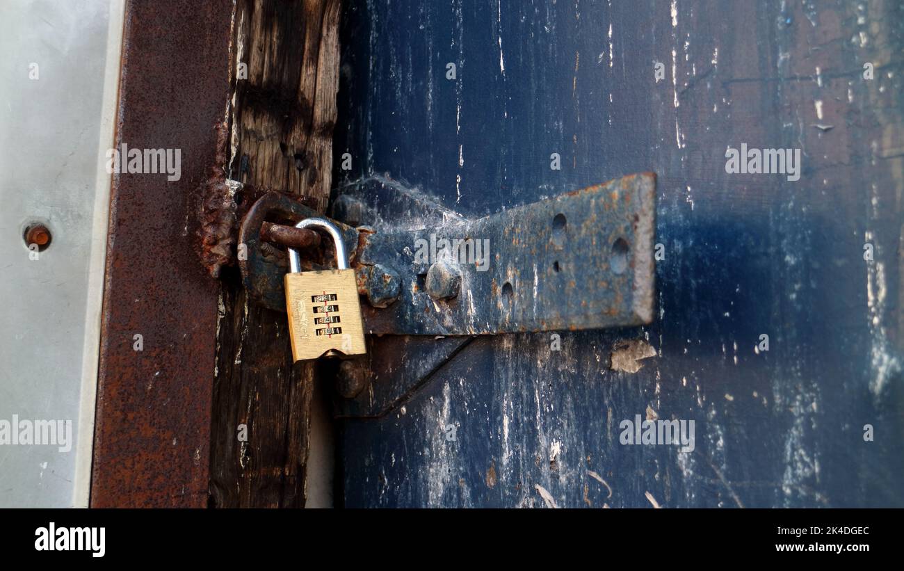 New golden lock in an old rustly latch Stock Photo - Alamy