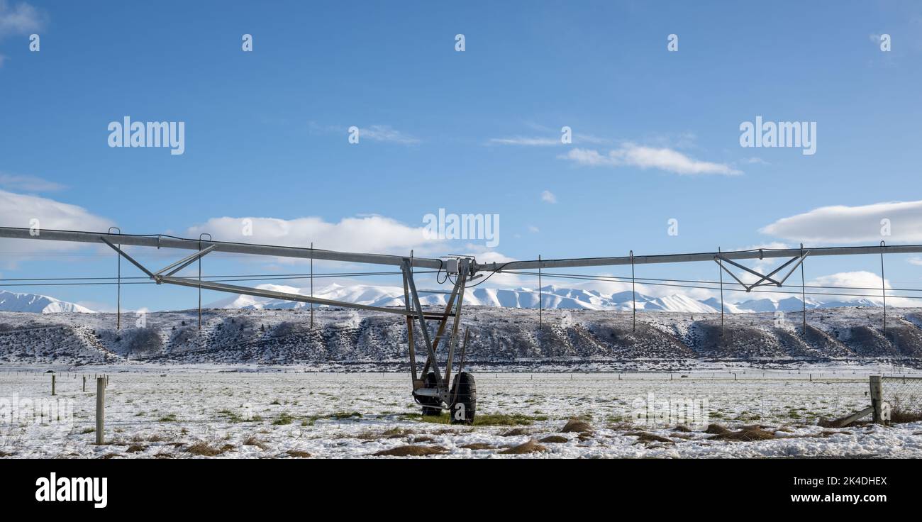 Sprinkler irrigation system on a snow-covered farmland with Ben Ohau ...