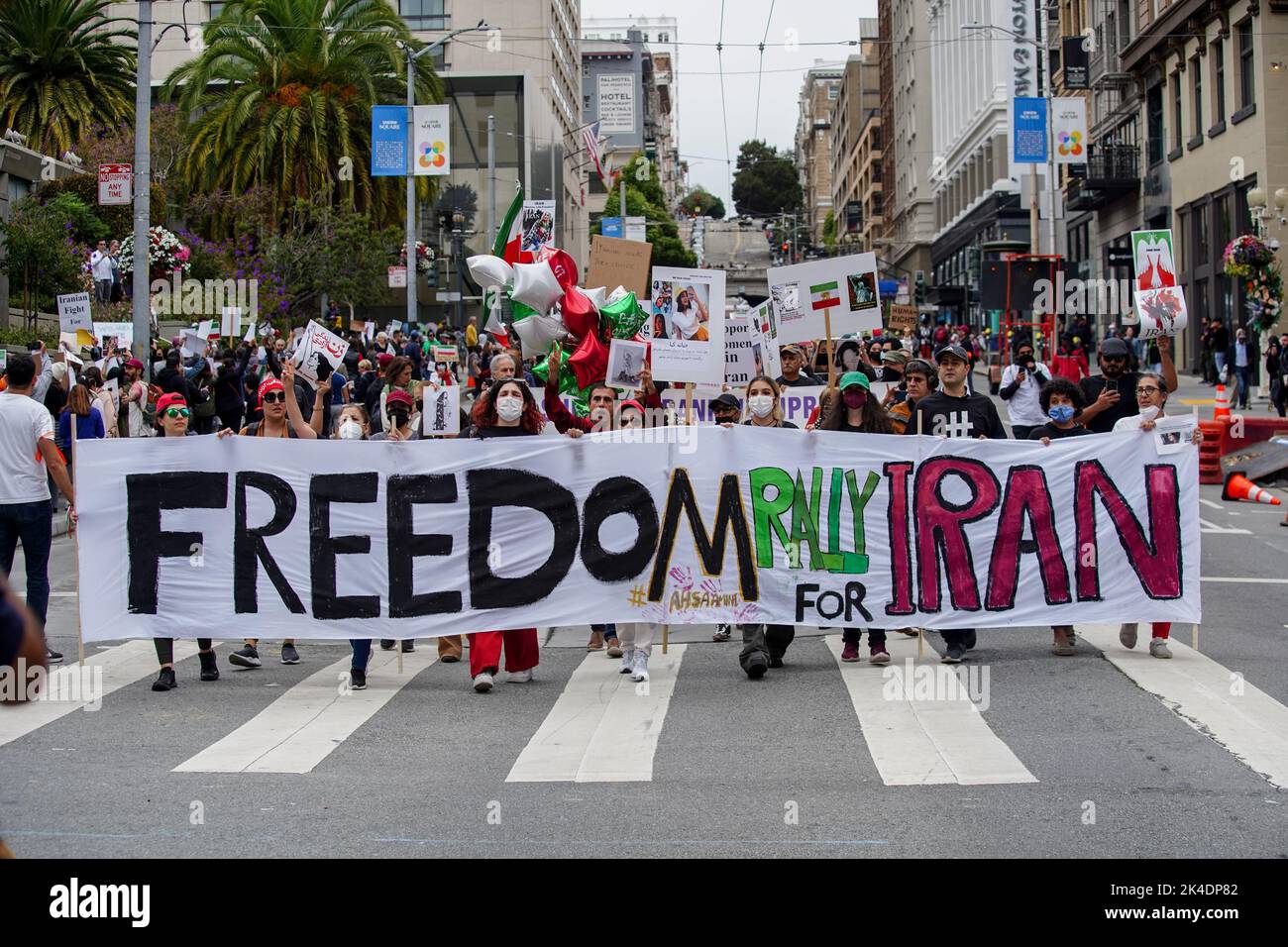 People march on the street of San Francisco with a large banner wrote ...