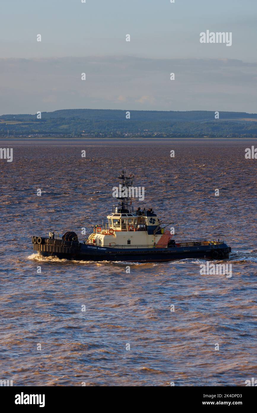 Tug heading to escort vessel into port Stock Photo - Alamy
