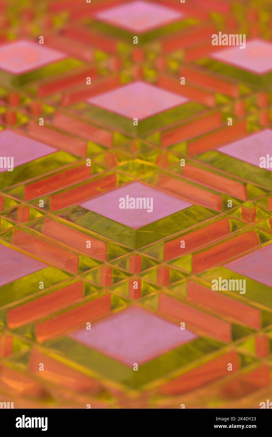 A flat plastic vibrant dark orange, pink and green coloured geometrical ...