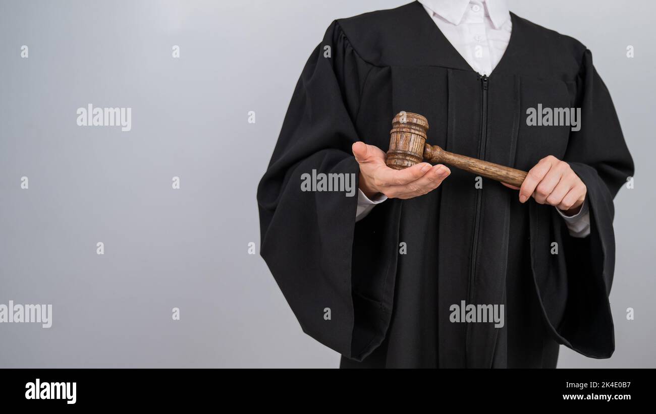 Faceless female judge in a robe holding a court gavel Stock Photo - Alamy
