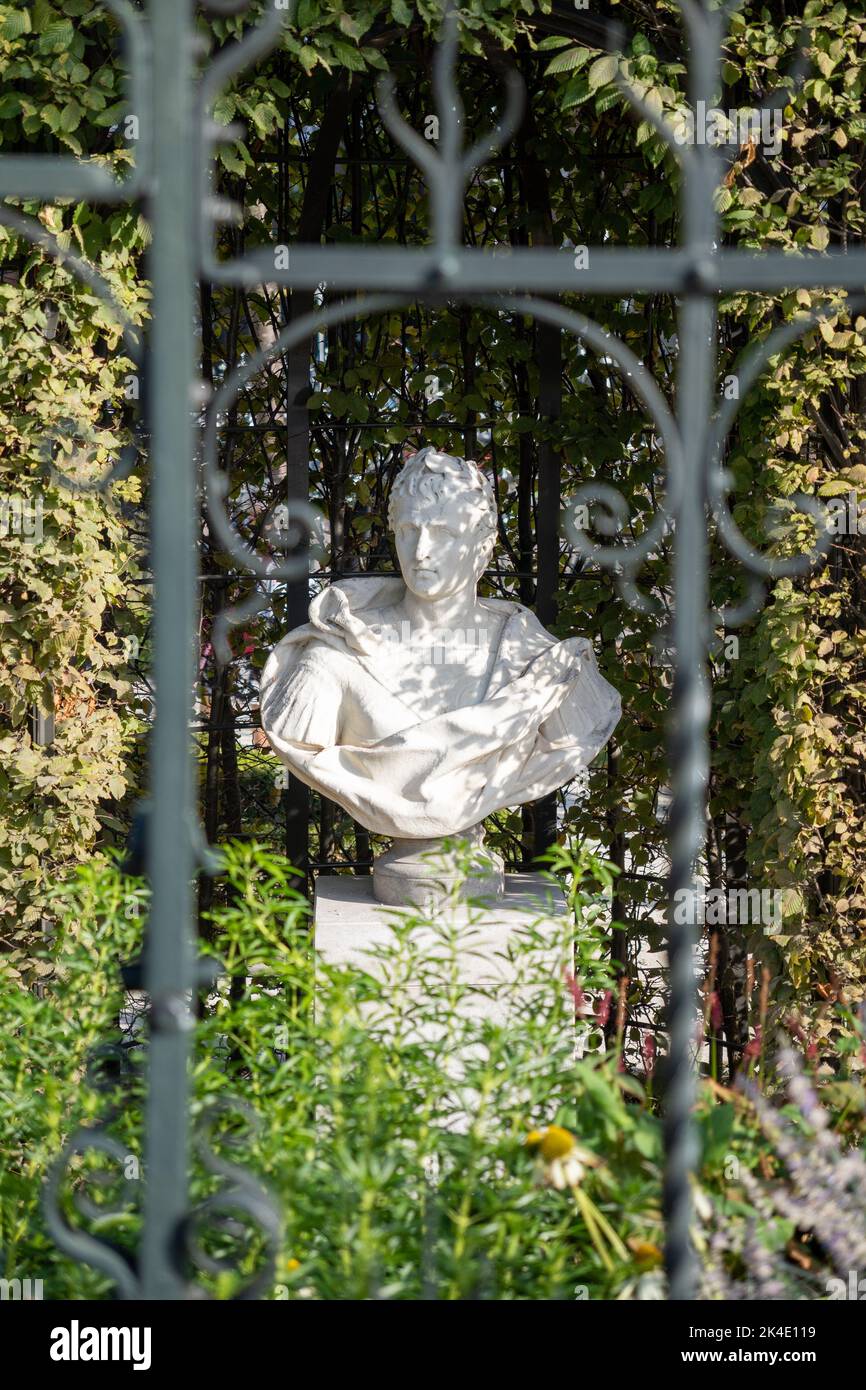 A vertical of Carrara Marble bust through metallic door in the park ...