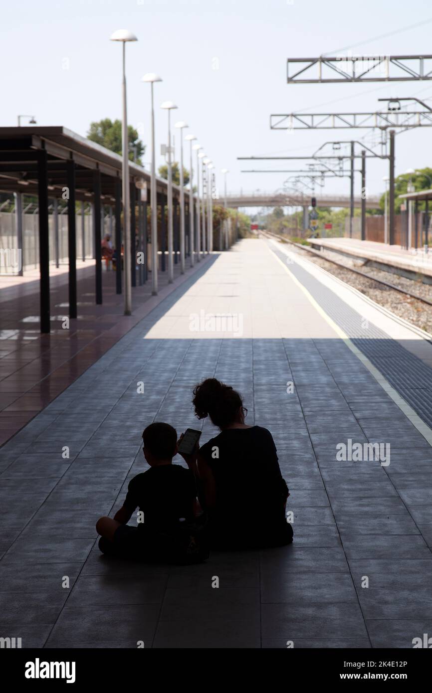 Mother and Child waiting on platform for train at Barcelona Airport ...