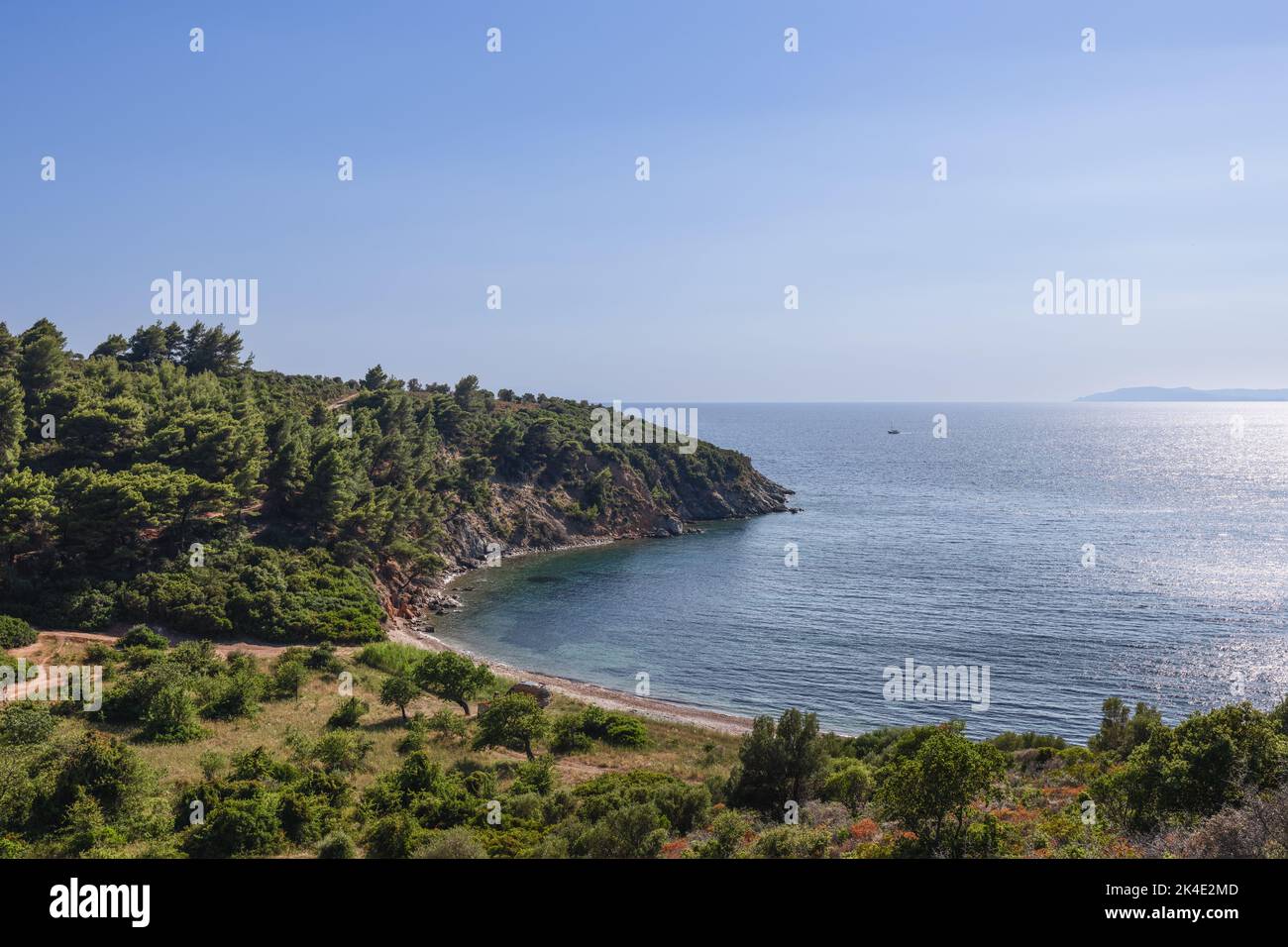 Narrow path leads along slopes of green hill to tiny beach and bay ...