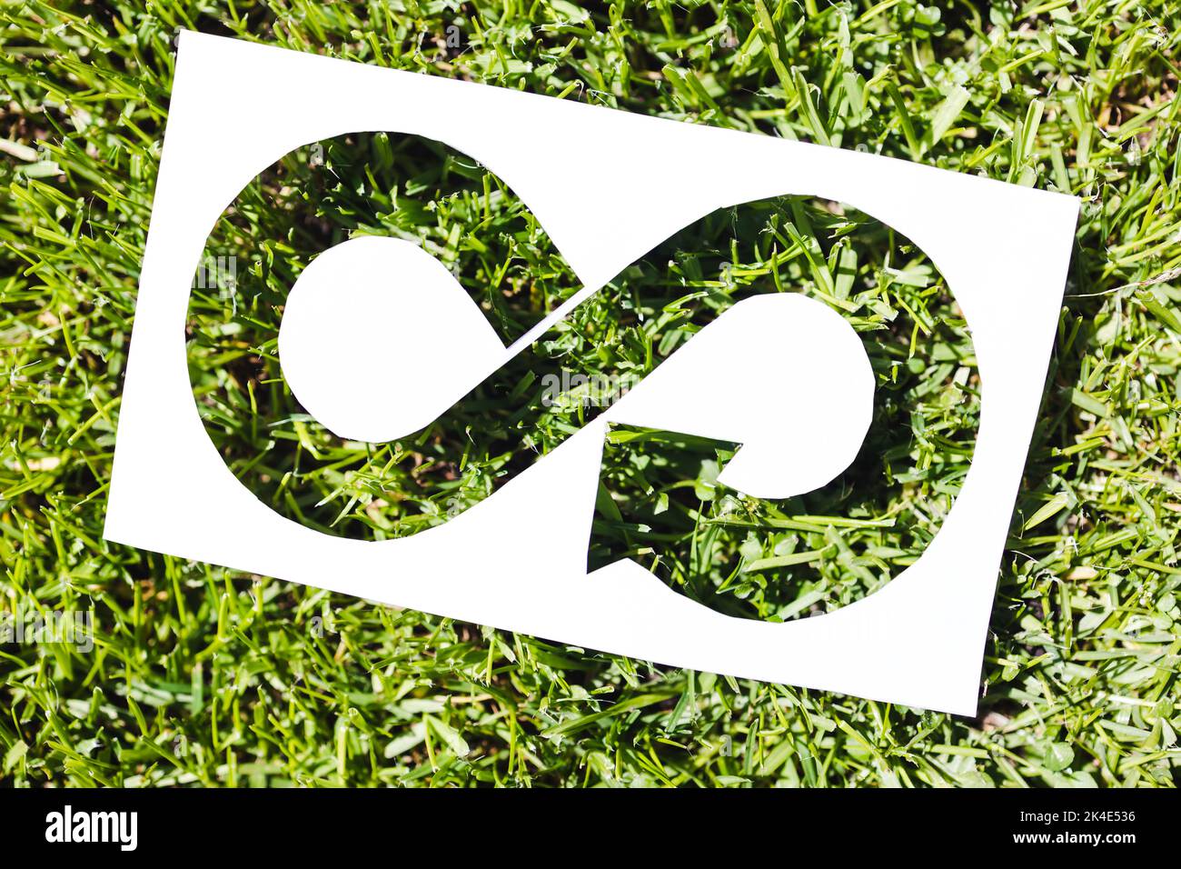 circular economy symbol on paper cutout with perfect green grass ...