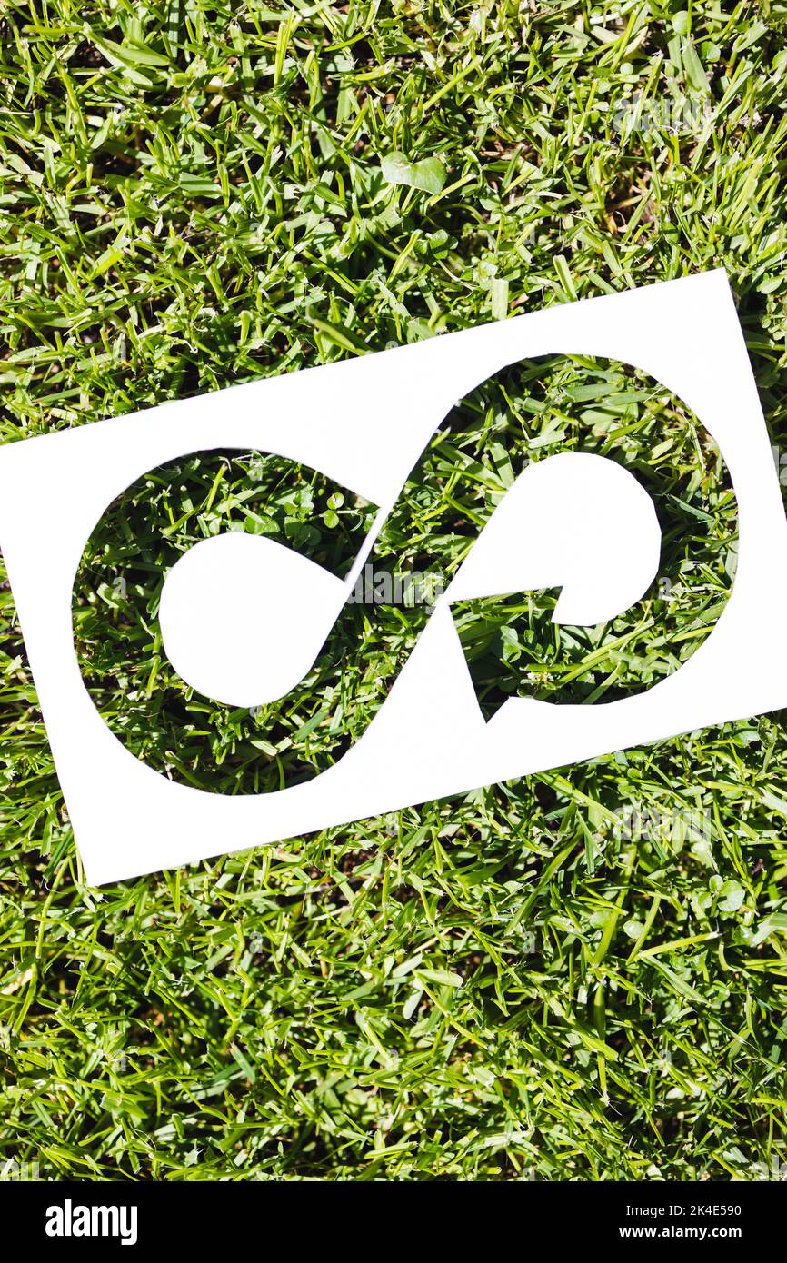 circular economy symbol on paper cutout with perfect green grass ...