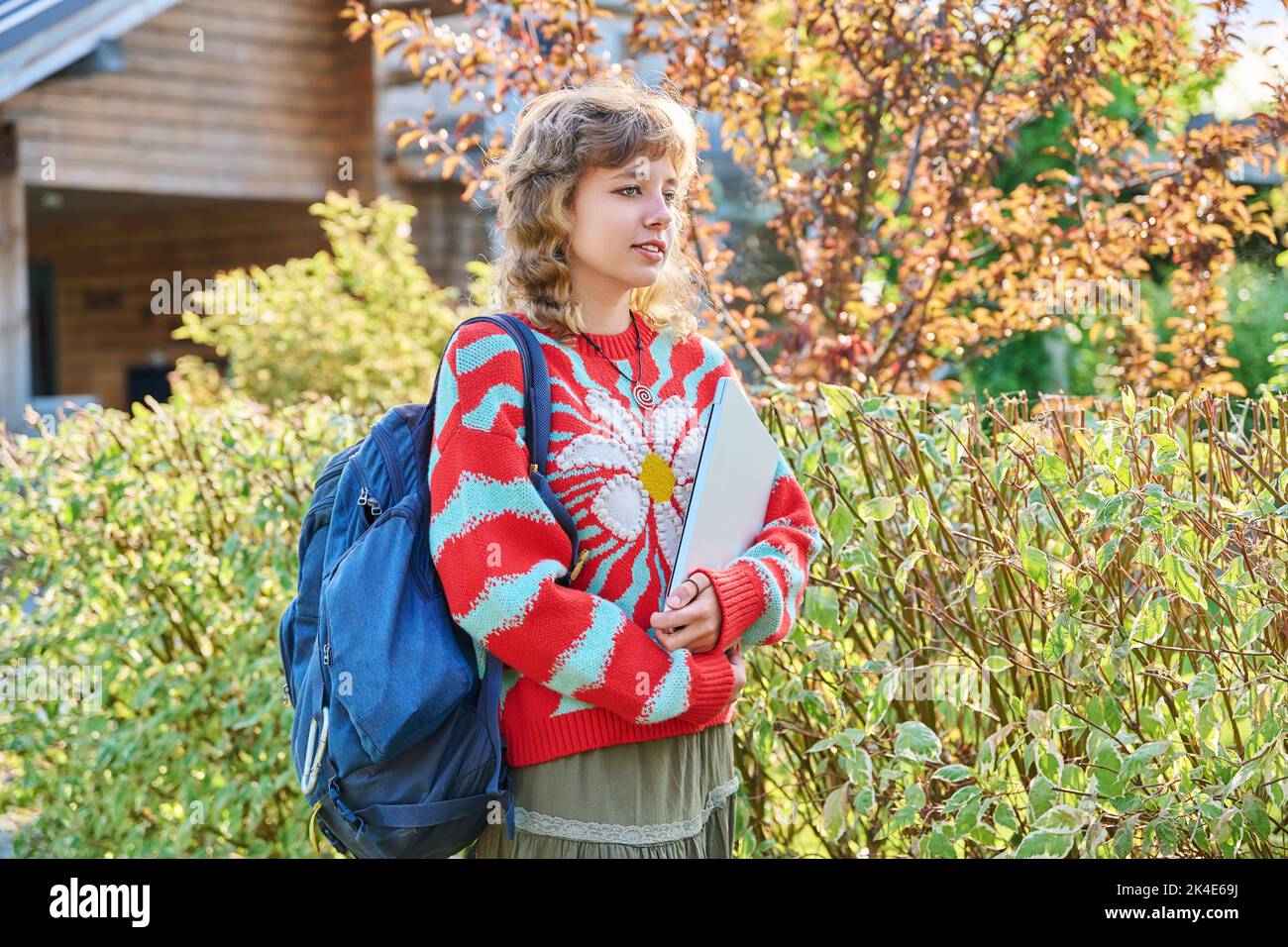 Teenage female student with laptop backpack in hands, outdoor Stock ...