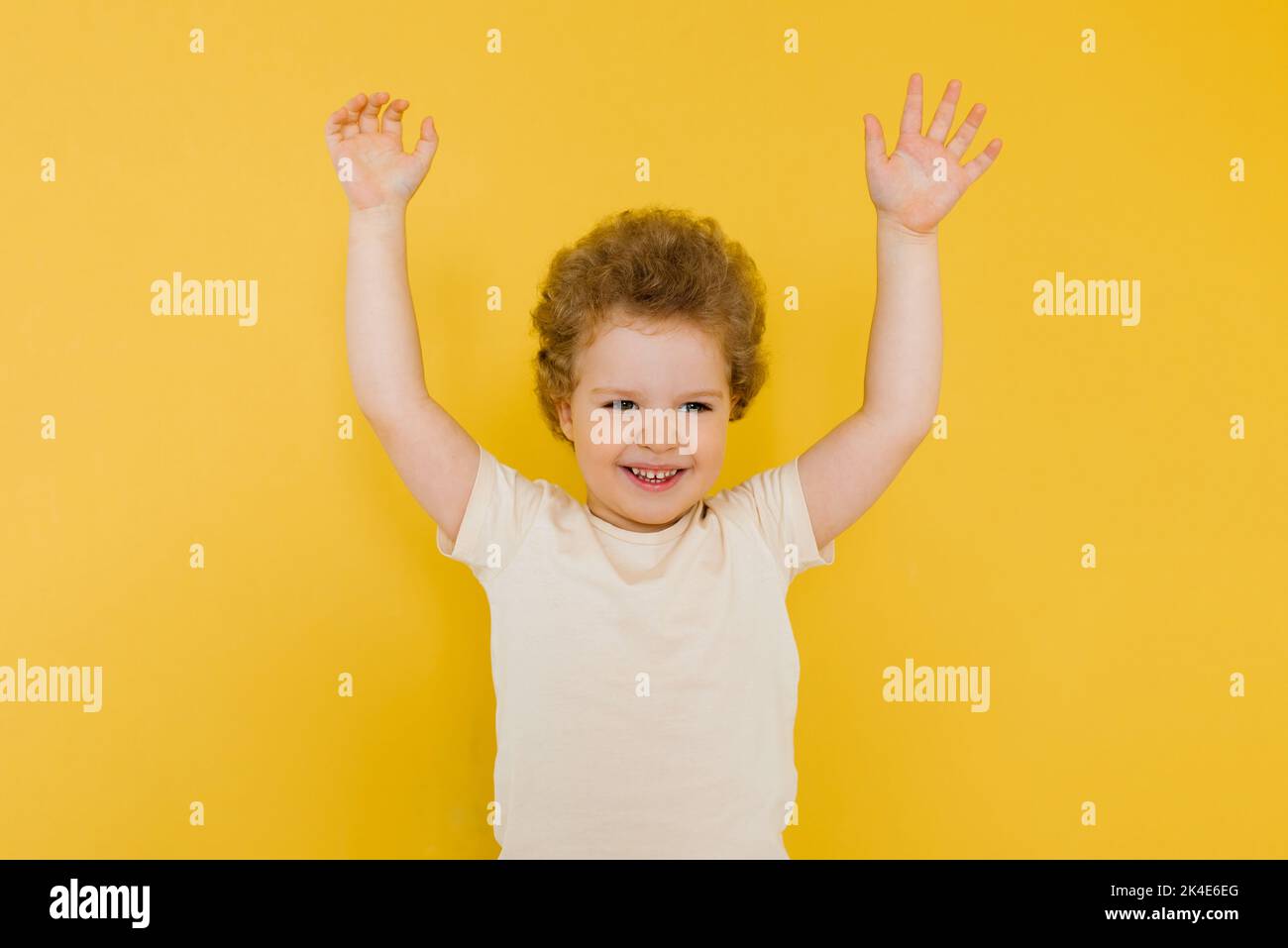 Happy cute four-year-old kid in a light T-shirt, raising his hands up ... Happy cute four-year-old kid in a light T-shirt, raising his hands up ...