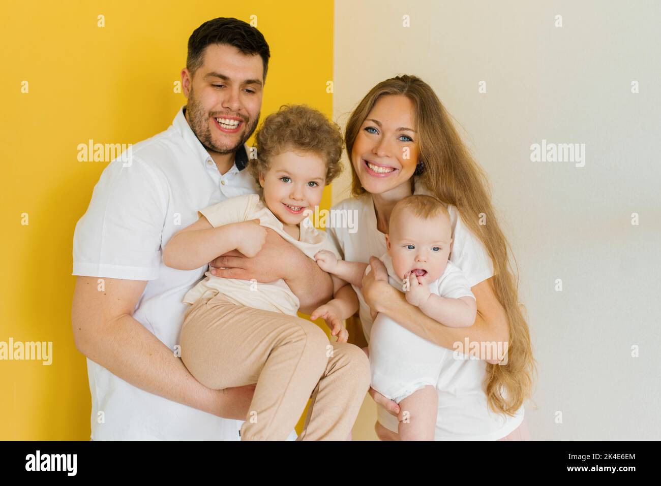 Young sincere family, where a happy father and mother hold their lovely ...