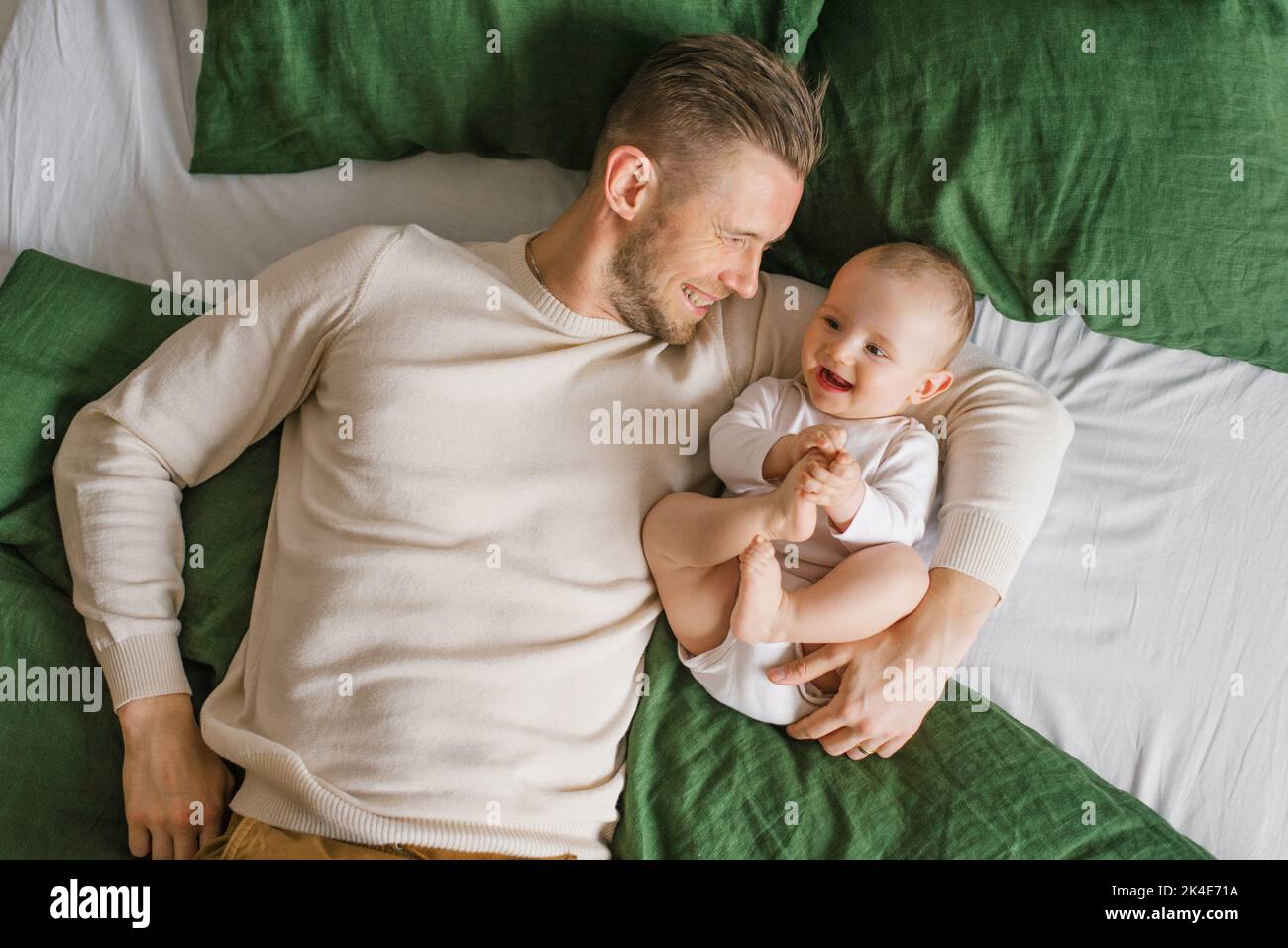 A happy father is lying on the bed with his little child. conception of ...