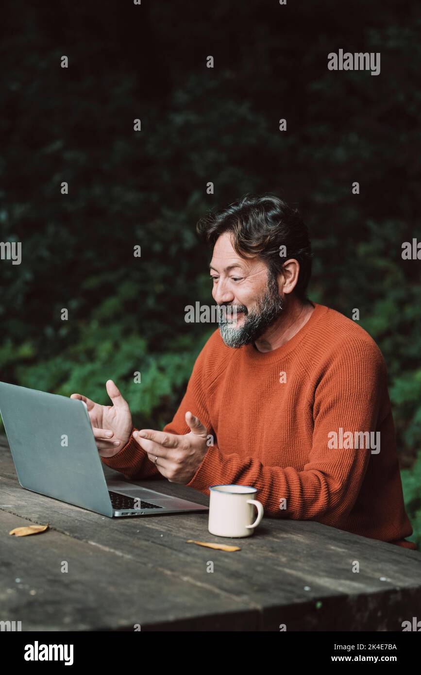 One man working on a laptop in outdoor workplace doing a video call web ...