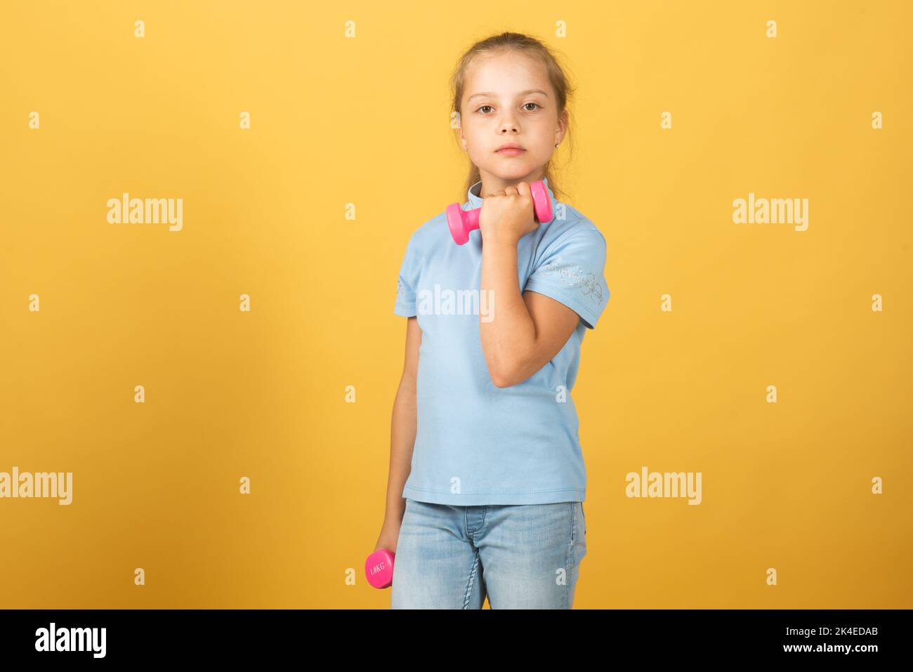 Sport child girl with strong biceps muscles. Kids exercising fitness dumbbells. Strong little ...