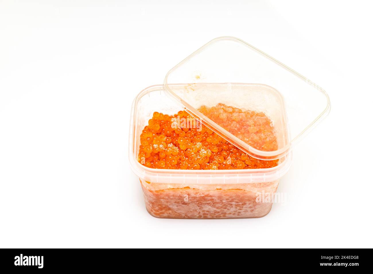 red caviar in a plastic container on a white background. High quality ...