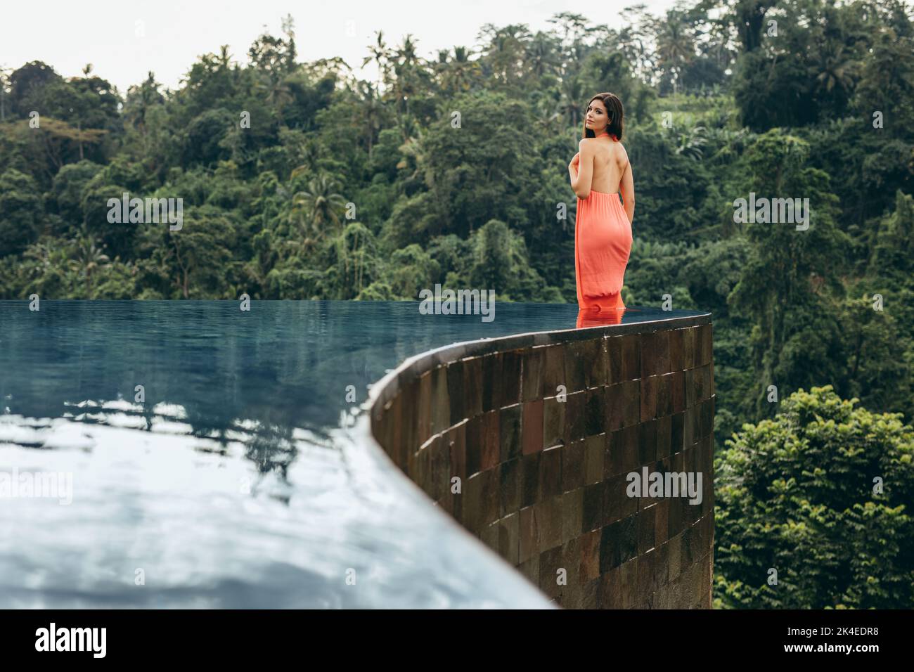 Shot of attractive young woman standing in infinity pool of holiday ...