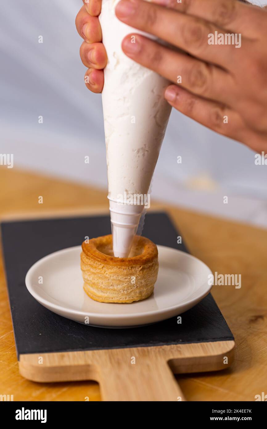 hand filling the vol au vent with cream Stock Photo - Alamy