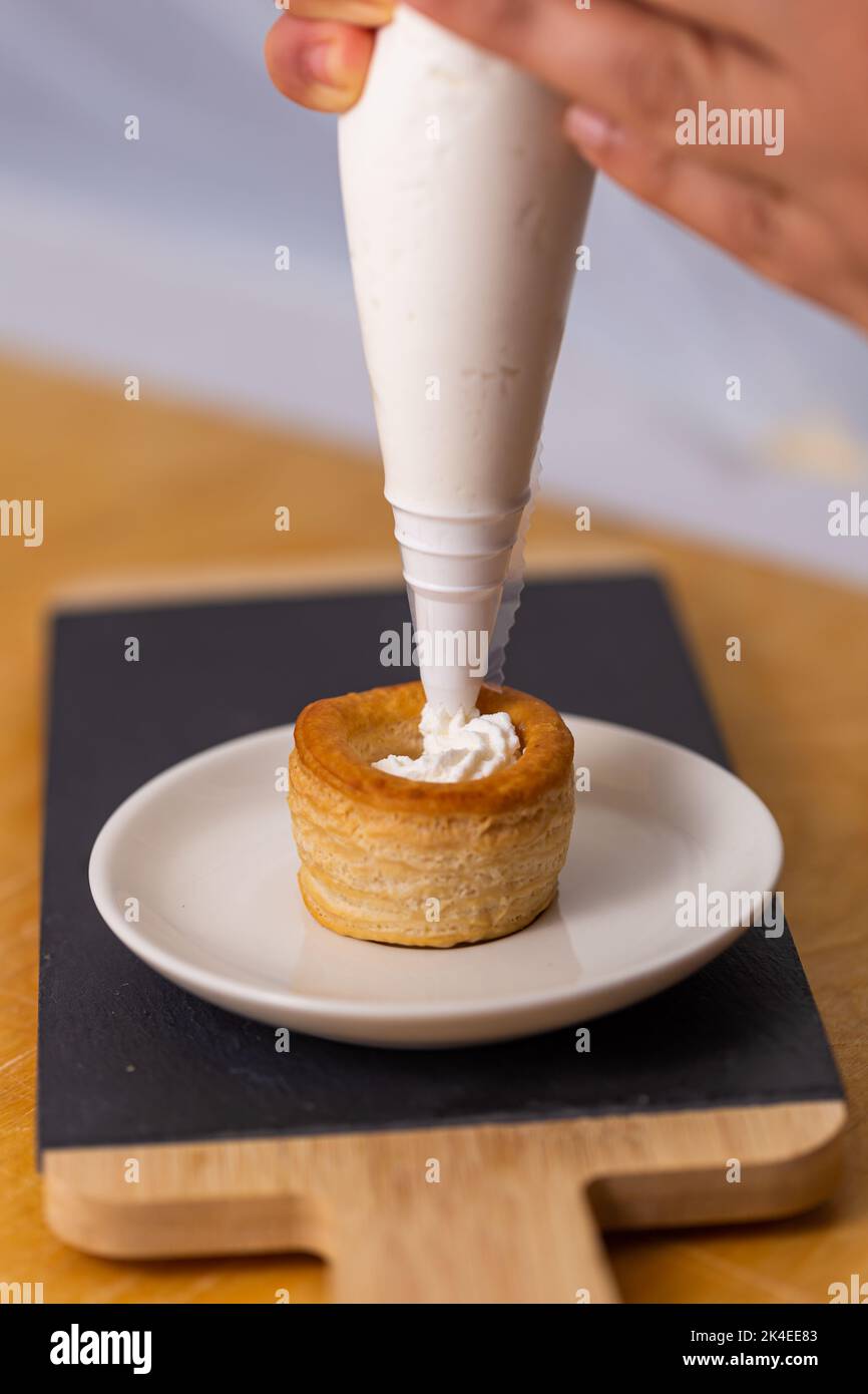 hand filling the vol au vent with cream Stock Photo - Alamy