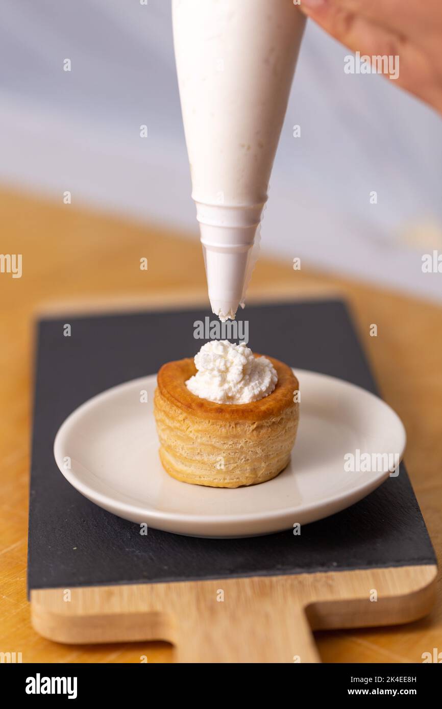 hand filling the vol au vent with cream Stock Photo - Alamy