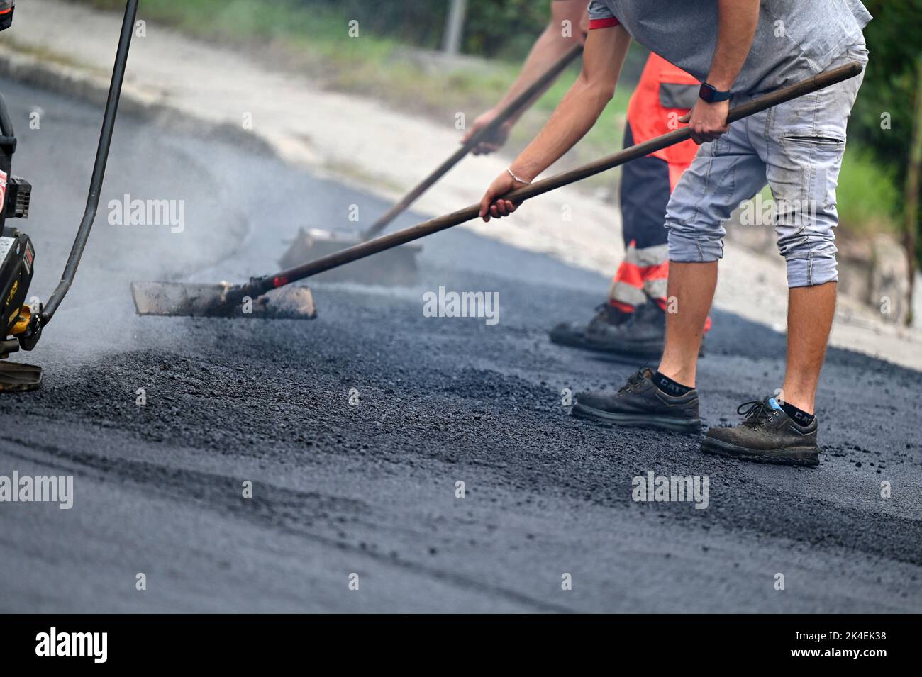 Feet of construction workers paving a road Stock Photo - Alamy