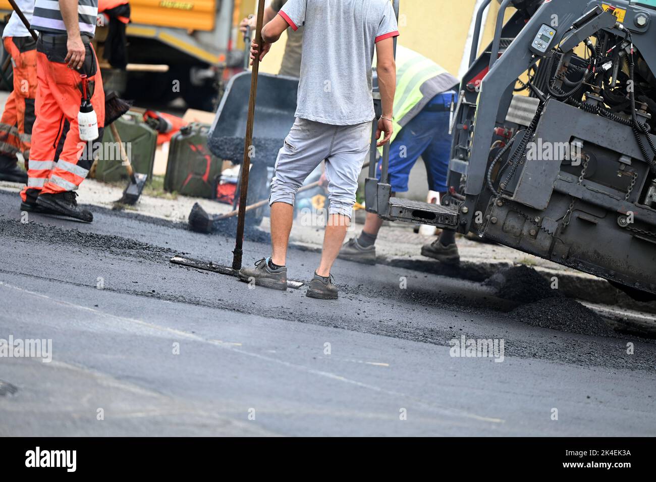 Feet of construction workers paving a road Stock Photo - Alamy