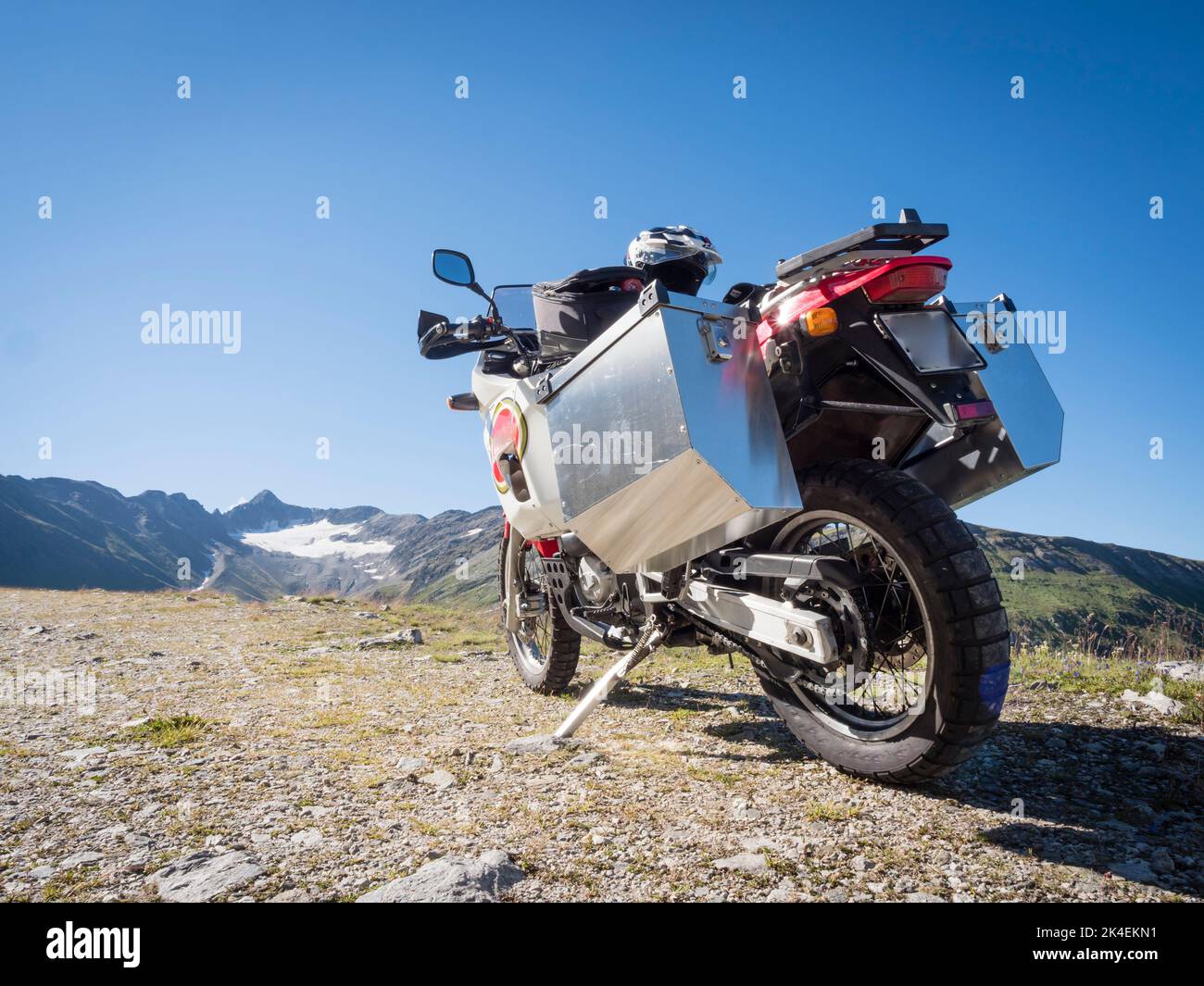 An adventure motorcycle with big aluminum cases is parked at a mountain ...
