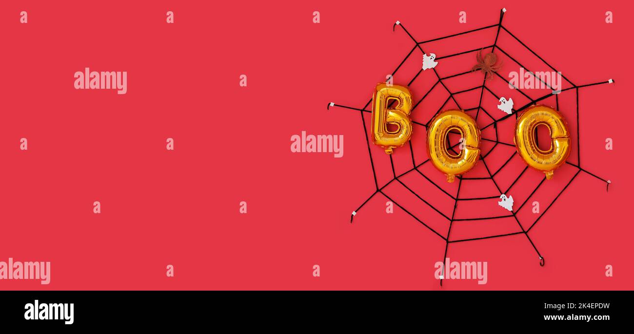 Word BOO made of balloons and Halloween decor on red background with ...