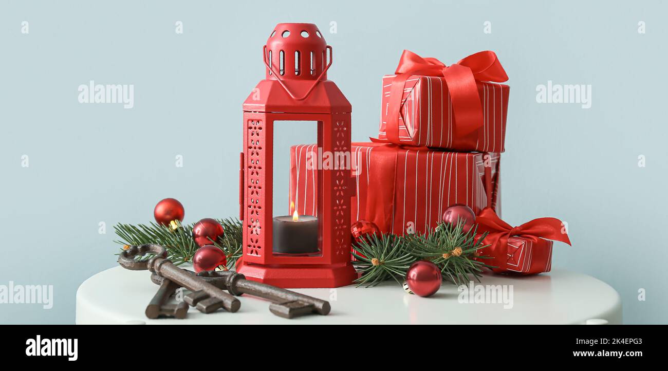 Composition with lantern, Christmas gifts and decorations on table ...