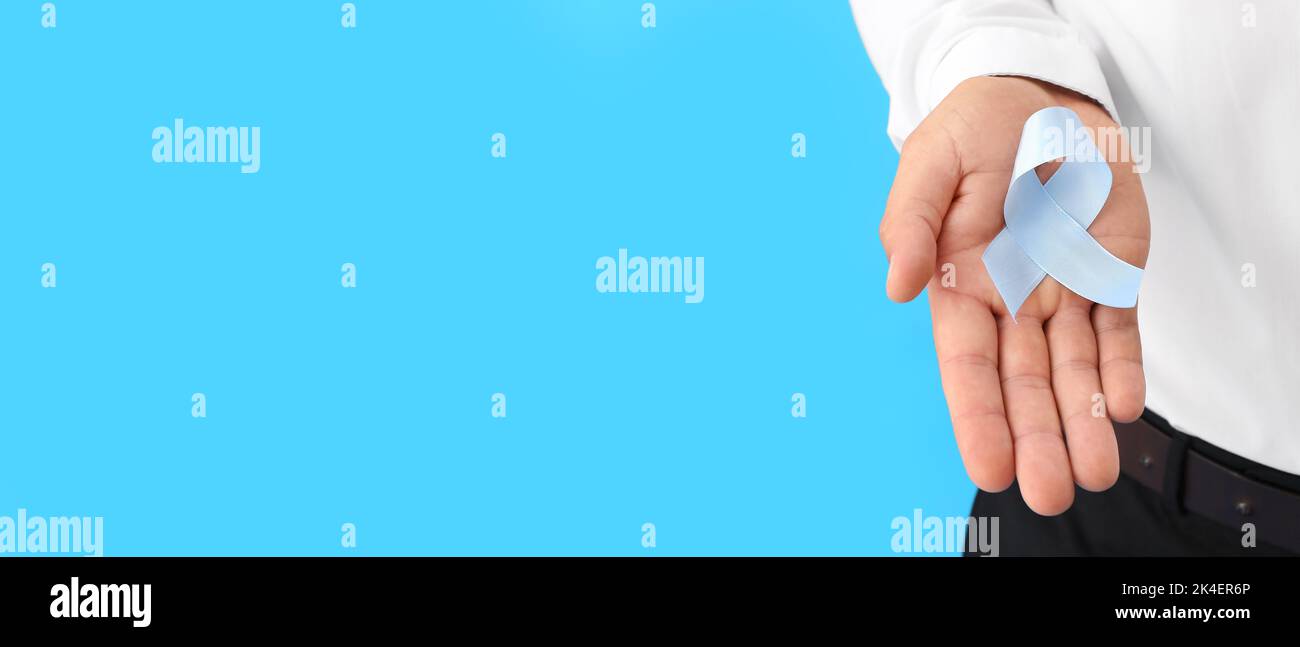 Man with light blue ribbon on color background with space for text ...