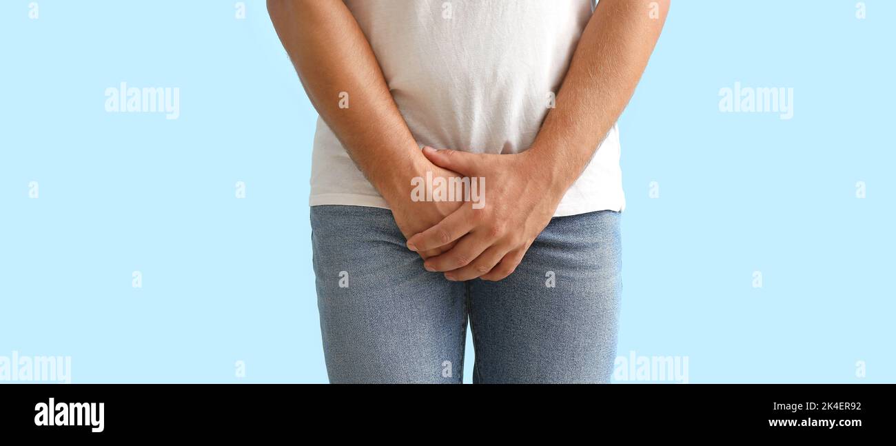 Man with prostate problem on light blue background, closeup Stock Photo ...