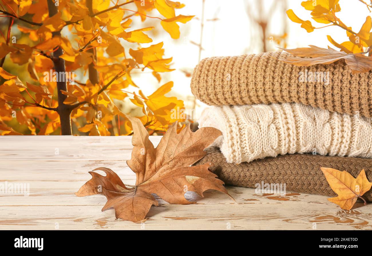 Stack of warm sweaters on table in autumn garden Stock Photo - Alamy