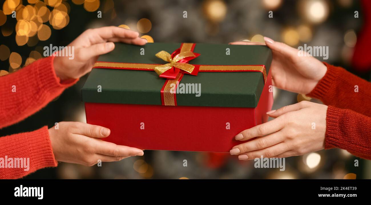 Woman giving present to her friend on Christmas eve, closeup Stock ...