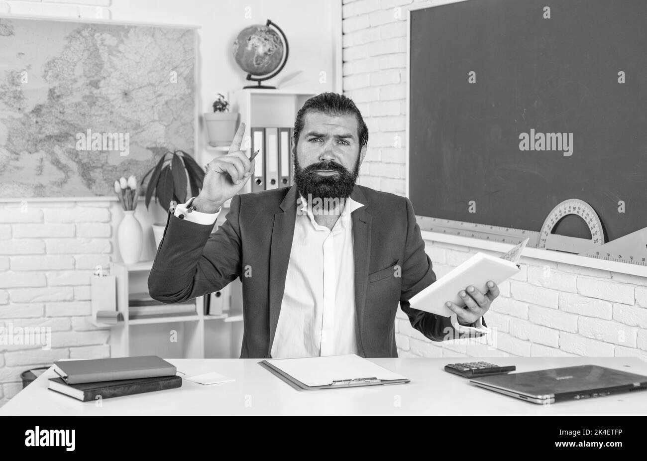 inspired student hold finger as he had an idea holding book in hand ...