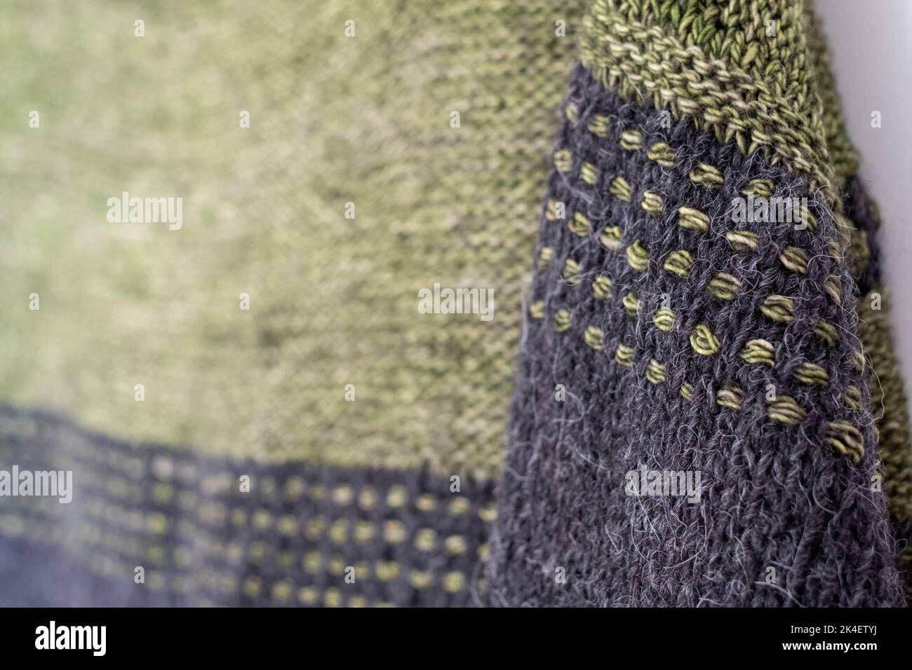 Details of green and dark grey woollen hand knitted sweater with ...