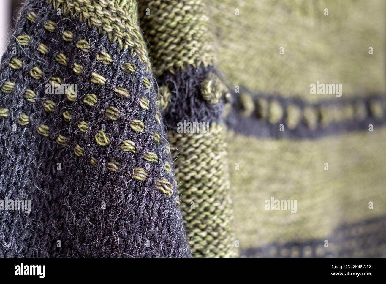 Details of green and dark grey woollen hand knitted sweater with ...
