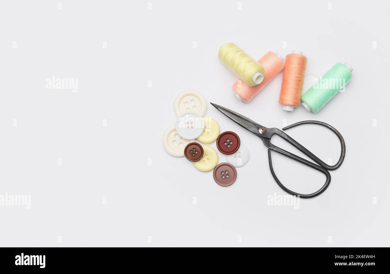 Scissors, buttons and spools of thread on white background Stock Photo ...