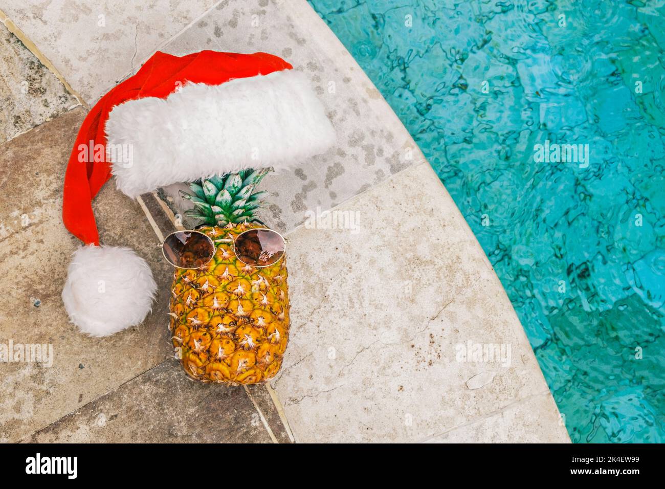 View from above of funny pineapple wearing sunglasses and Santa Claus ...