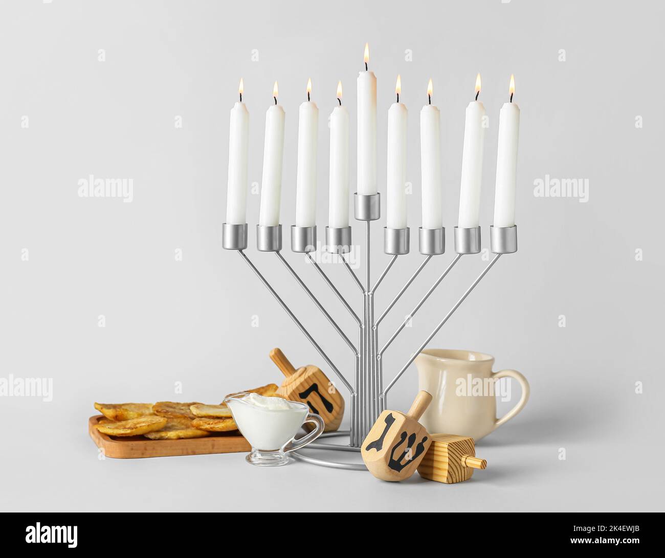 Menorah with candles, potato pancakes, sauce and dreidels for Hanukkah ...
