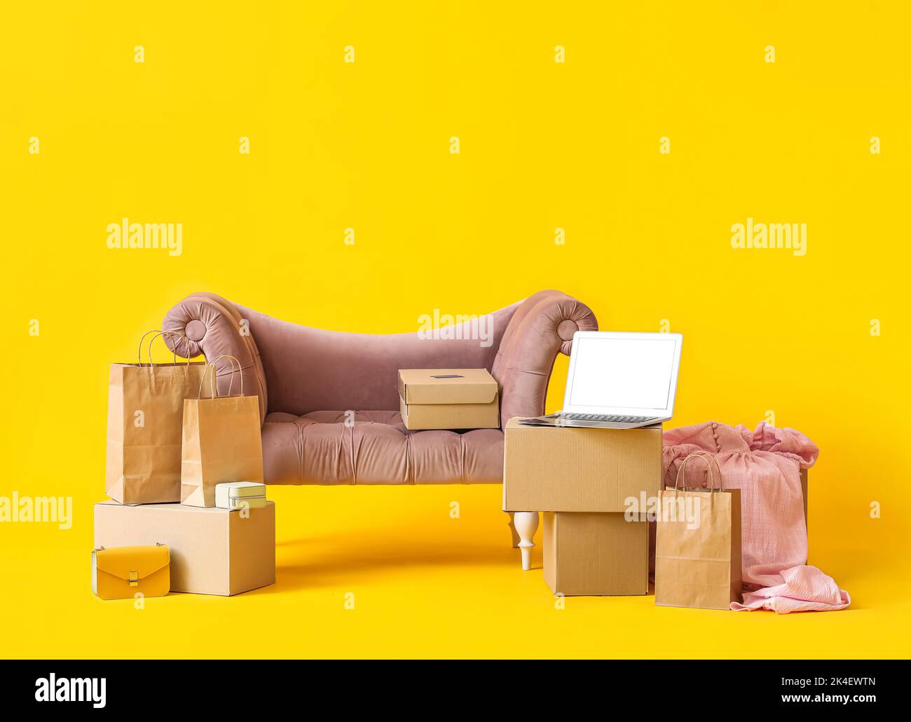 Armchair with laptop and parcels on yellow background. Online shopping ...