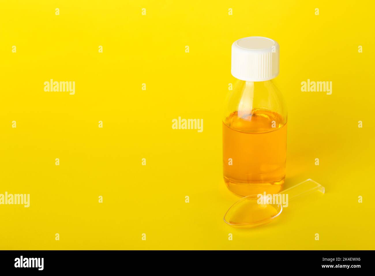 Bottle and spoon of cough syrup on yellow background Stock Photo - Alamy