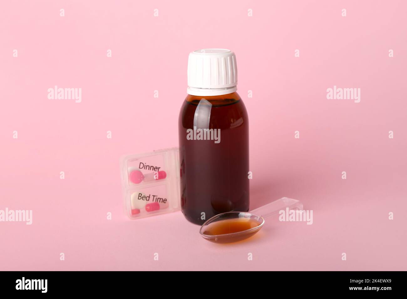 Bottle of cough syrup, spoon and pills on pink background Stock Photo ...