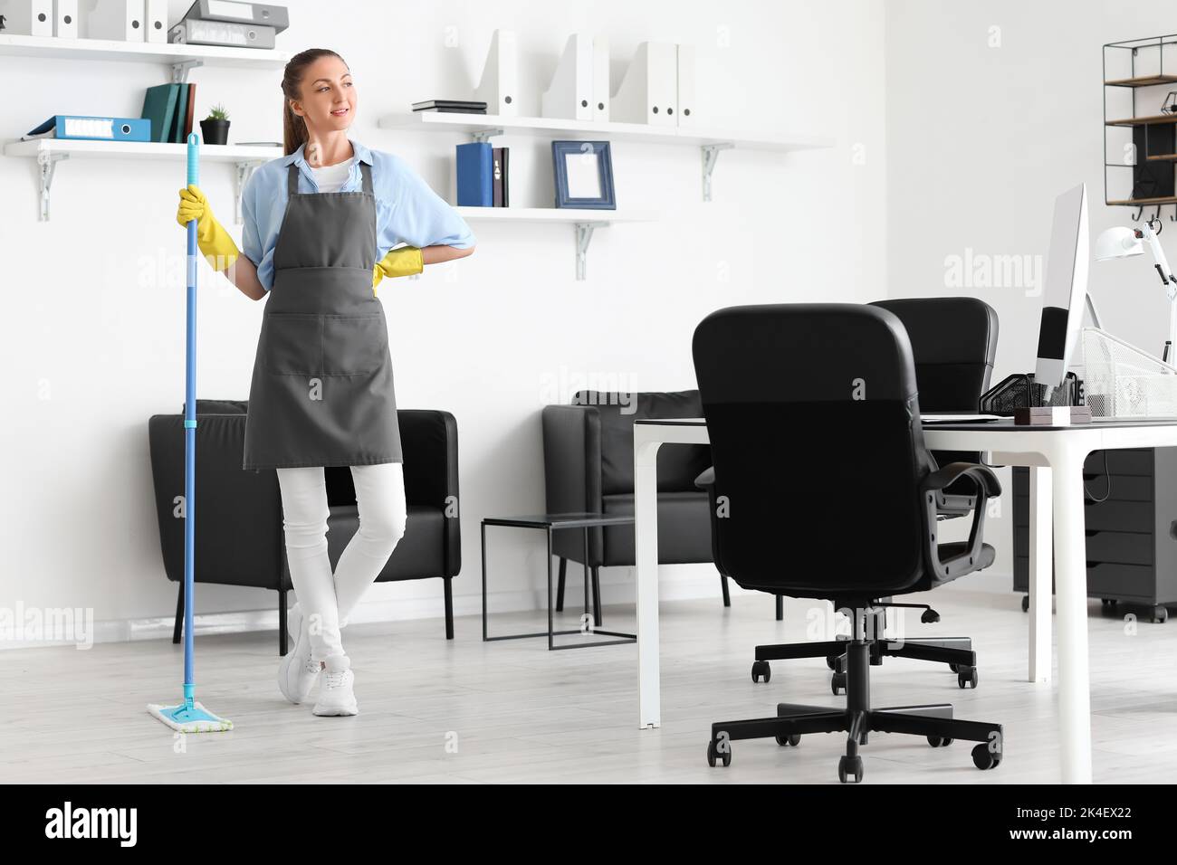 Female worker of cleaning service with mop in office Stock Photo - Alamy