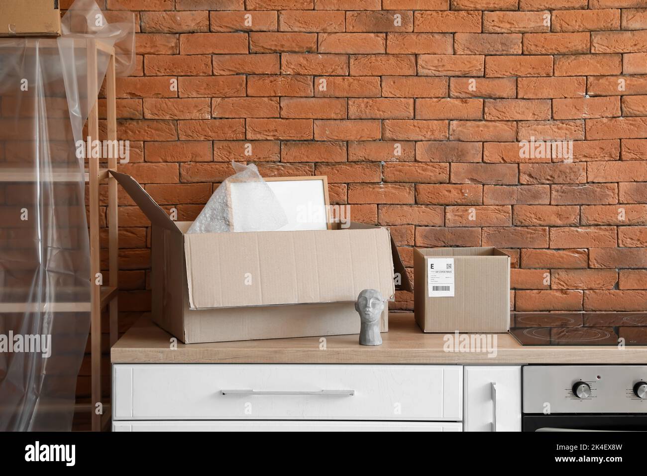 Counter with cardboard boxes and things in modern kitchen on moving day ...