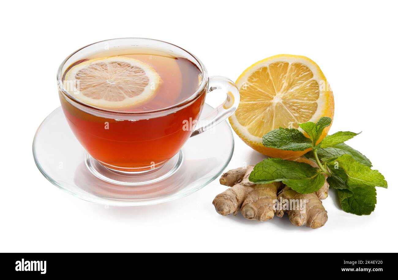 Glass cup of black tea with lemon, mint and ginger on white background ...