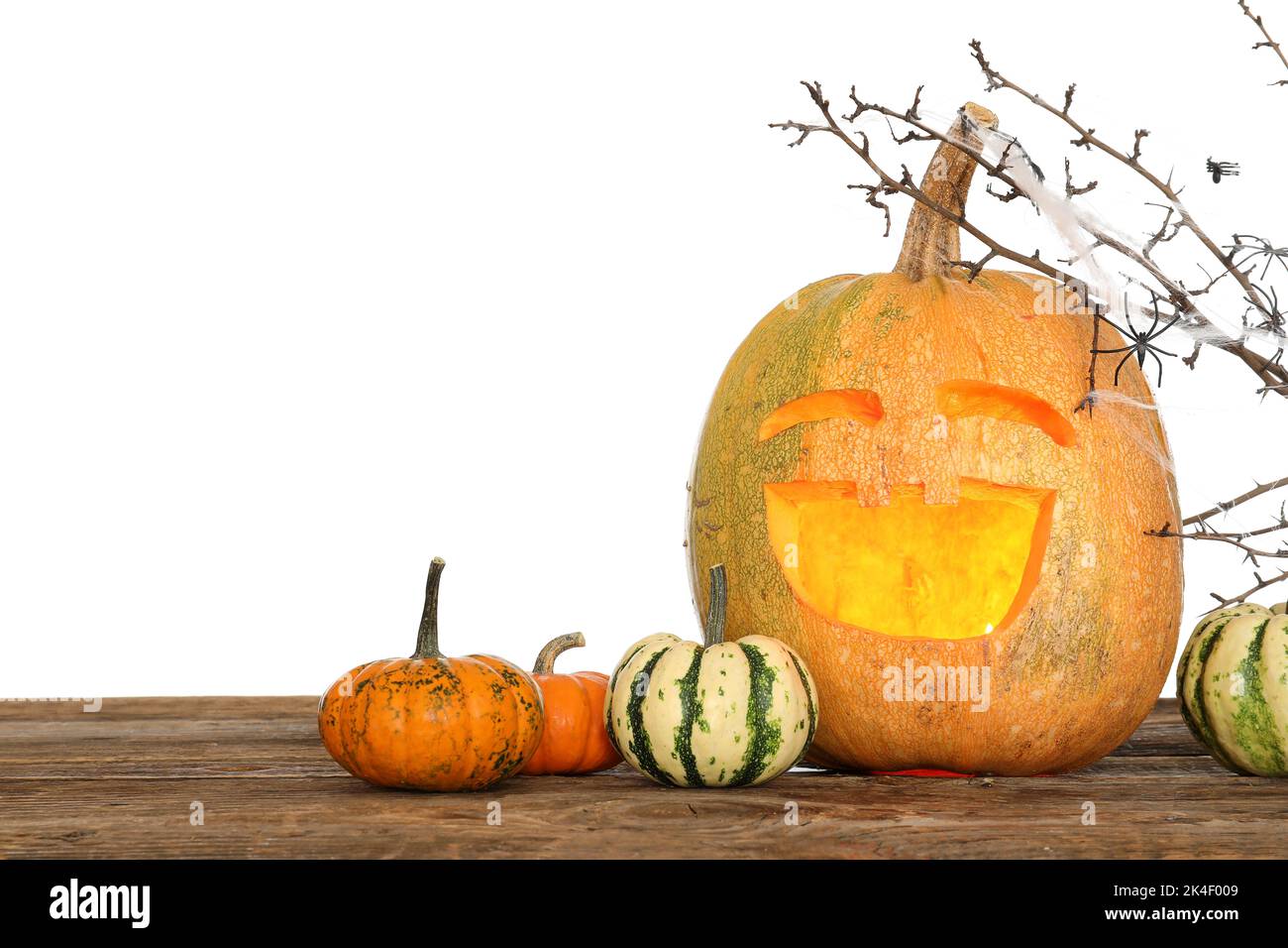 Halloween pumpkins with tree branches on table against white background ...