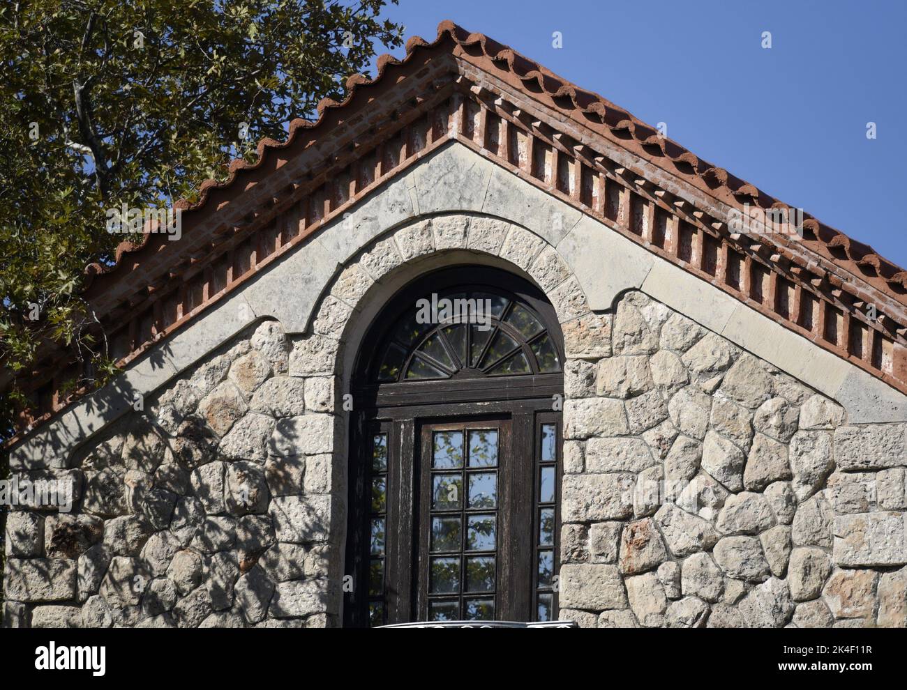 Arched wooden window on a handcrafted stone wall of the Pantelis ...
